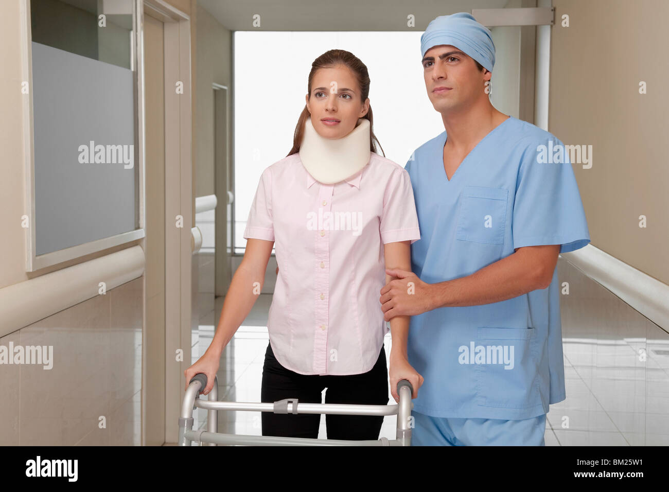 Doctor assisting a patient to walk in a hospital corridor Stock Photo ...