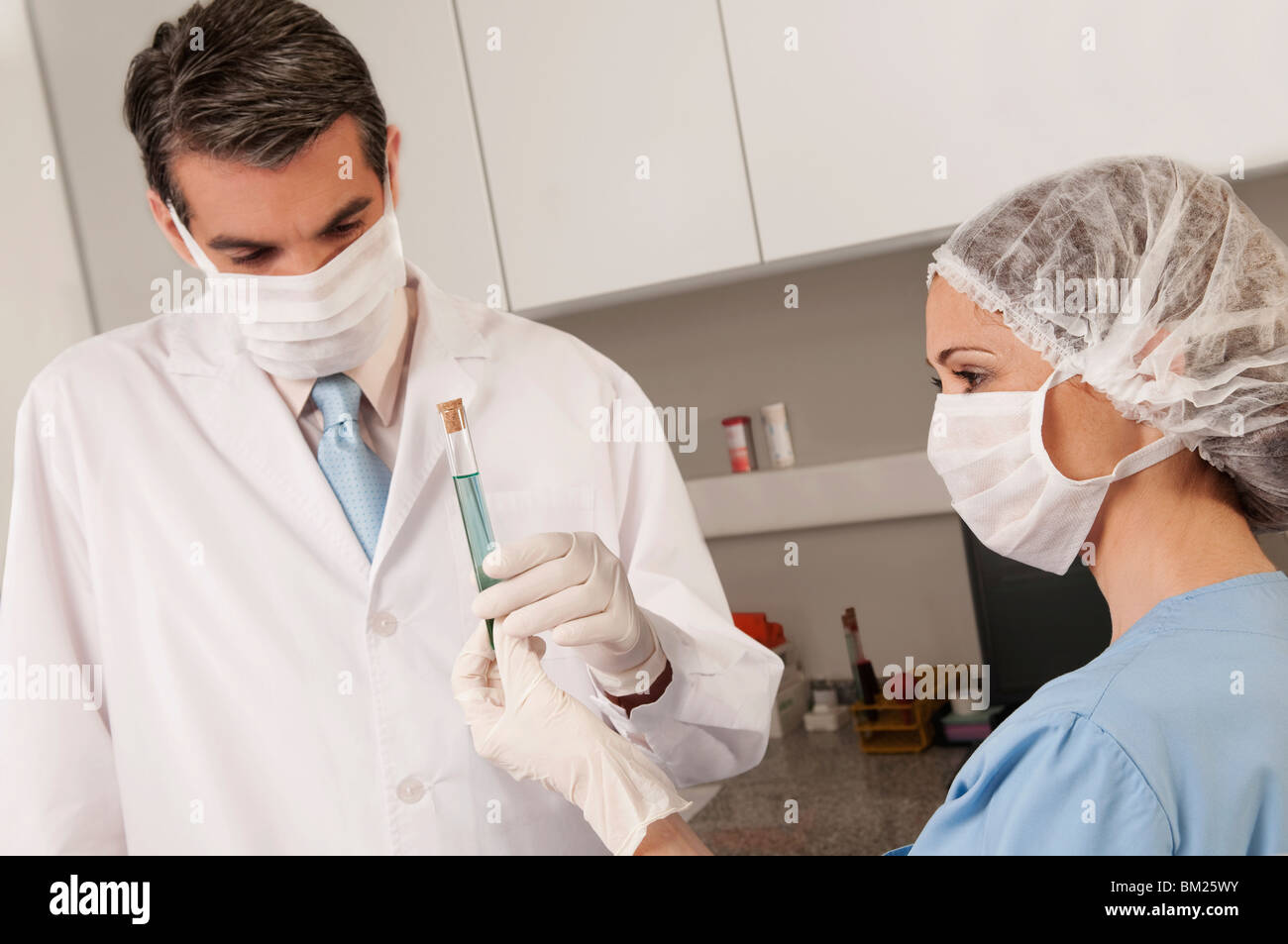 Lab technicians analyzing a sample in a test tube Stock Photo - Alamy