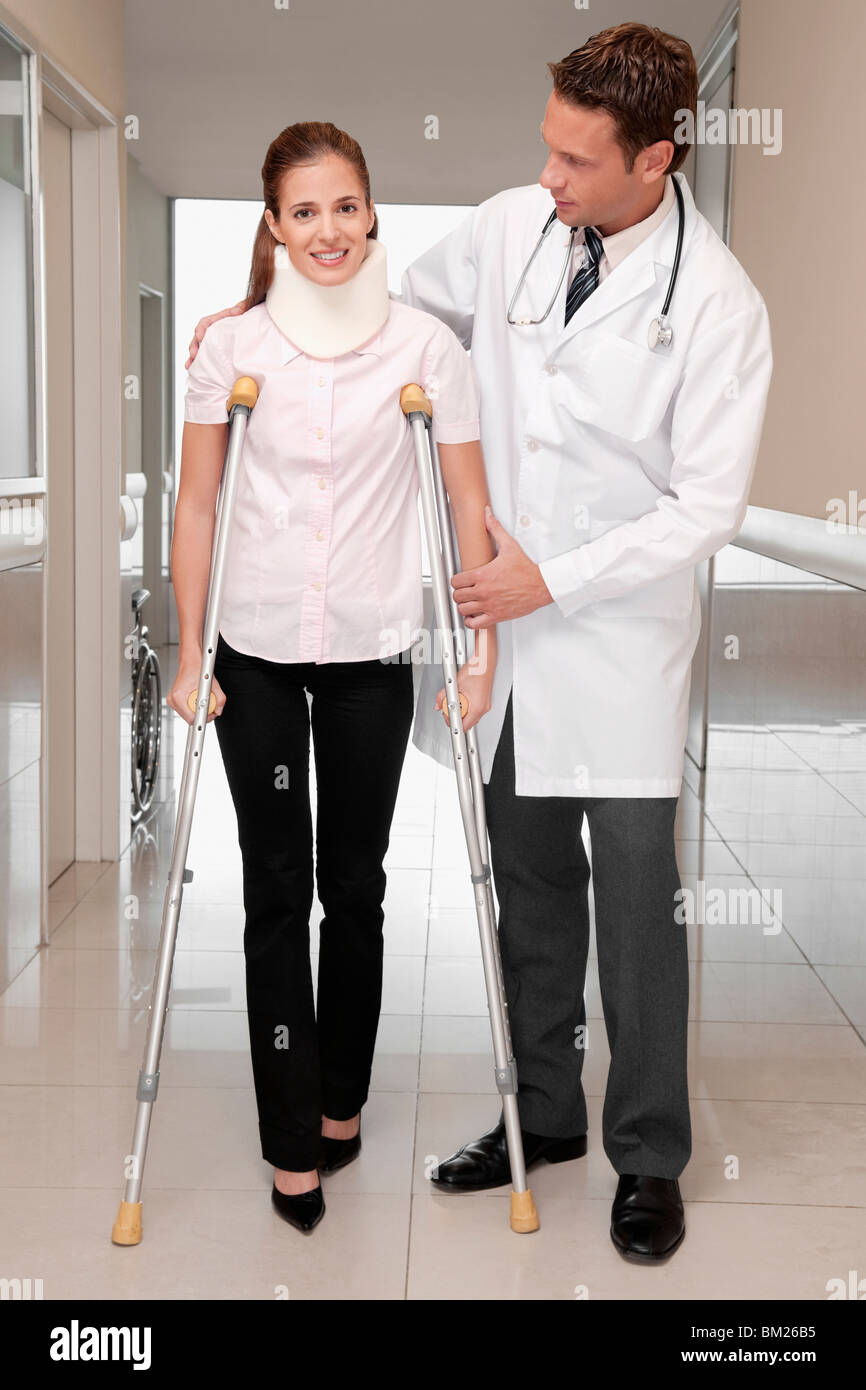 Doctor assisting a patient to walk in a hospital corridor Stock Photo ...