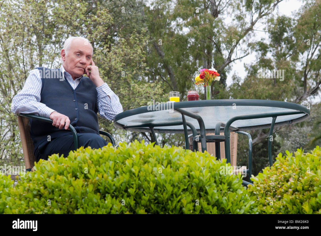 Man sitting in a garden and thinking Stock Photo - Alamy
