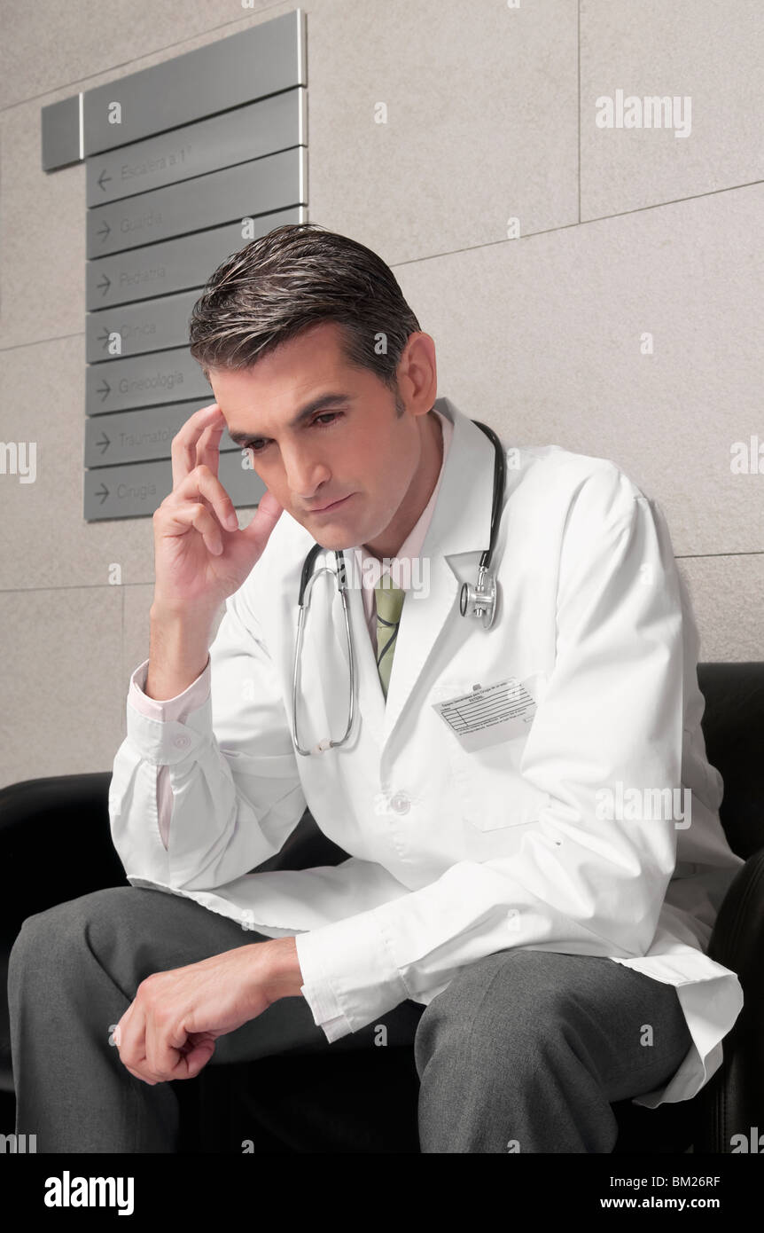 Doctor sitting on a chair and thinking Stock Photo - Alamy
