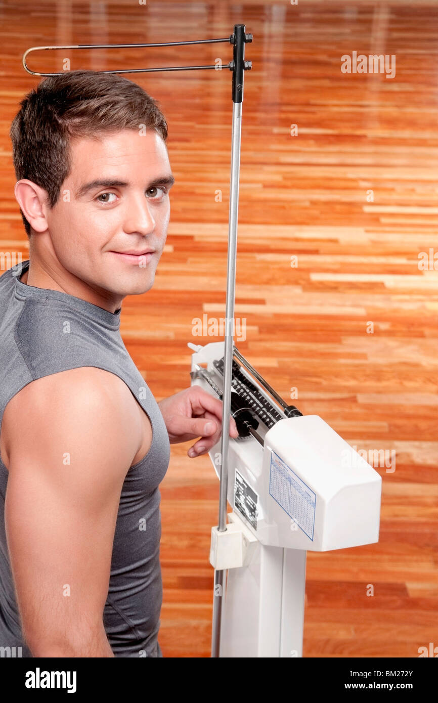 Man measuring his weight on a weighing scale Stock Photo - Alamy