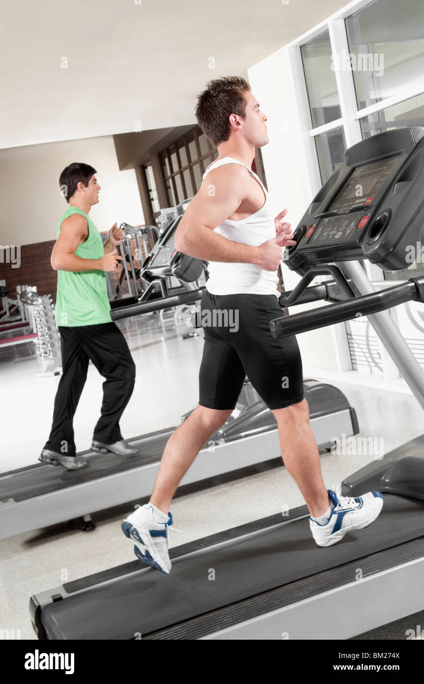 Two men running on treadmills Stock Photo - Alamy