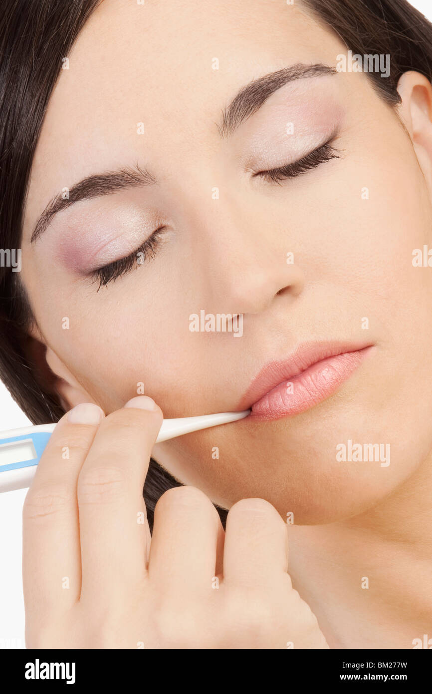 Woman taking her temperature Stock Photo - Alamy