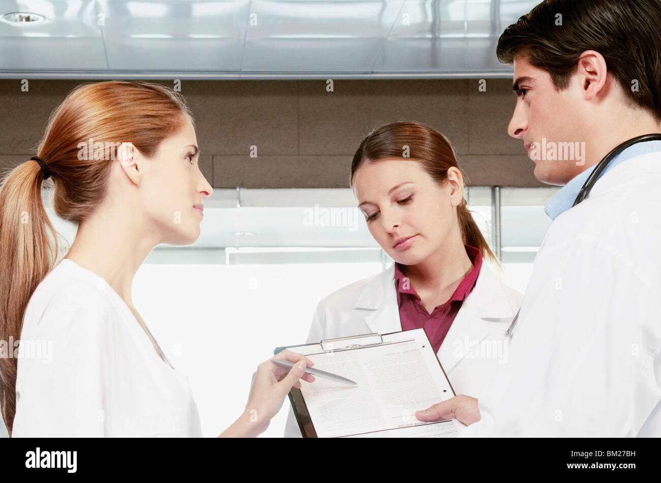 Three doctors discussing a report Stock Photo - Alamy