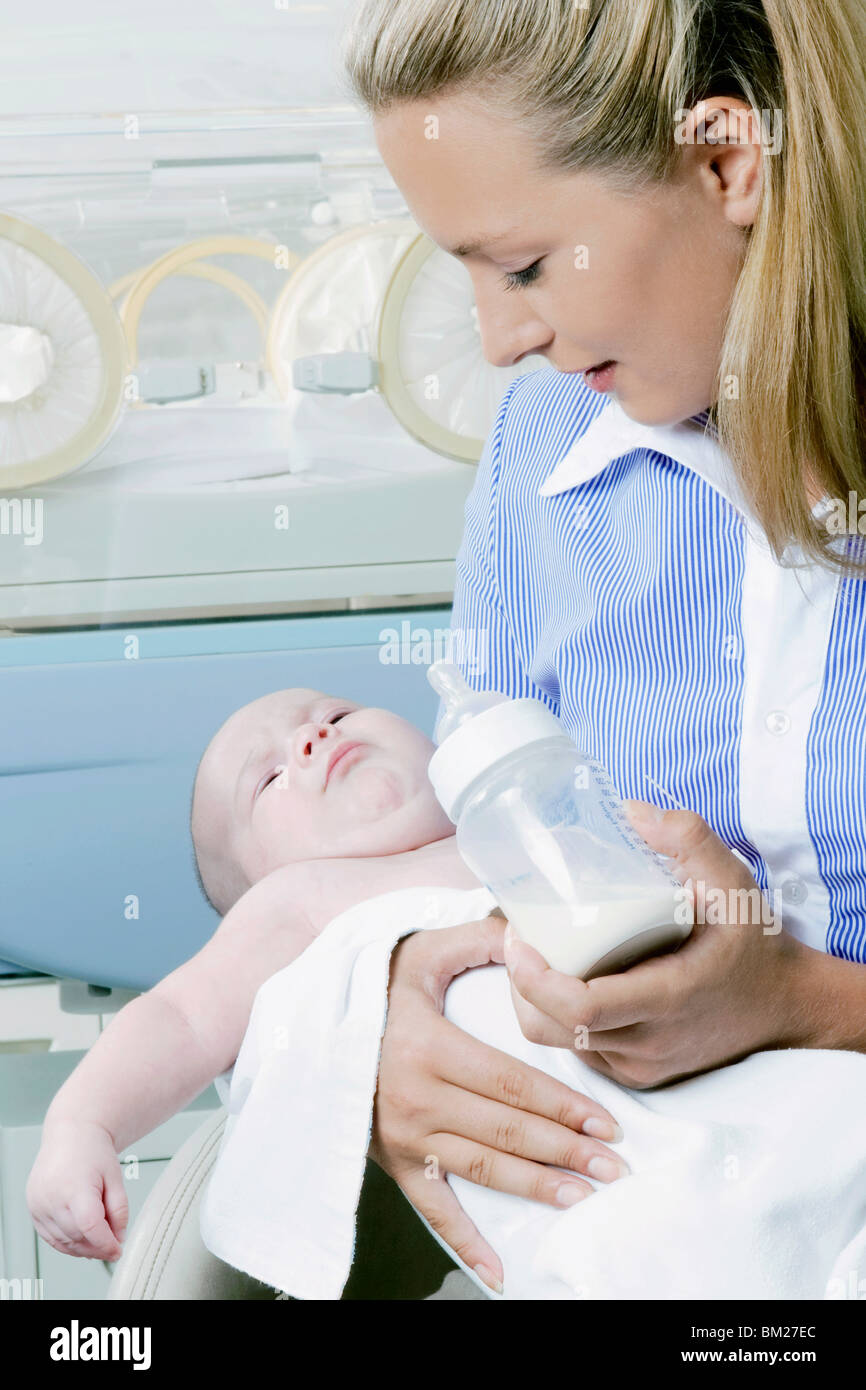 Woman feeding her baby from a milk bottle Stock Photo - Alamy