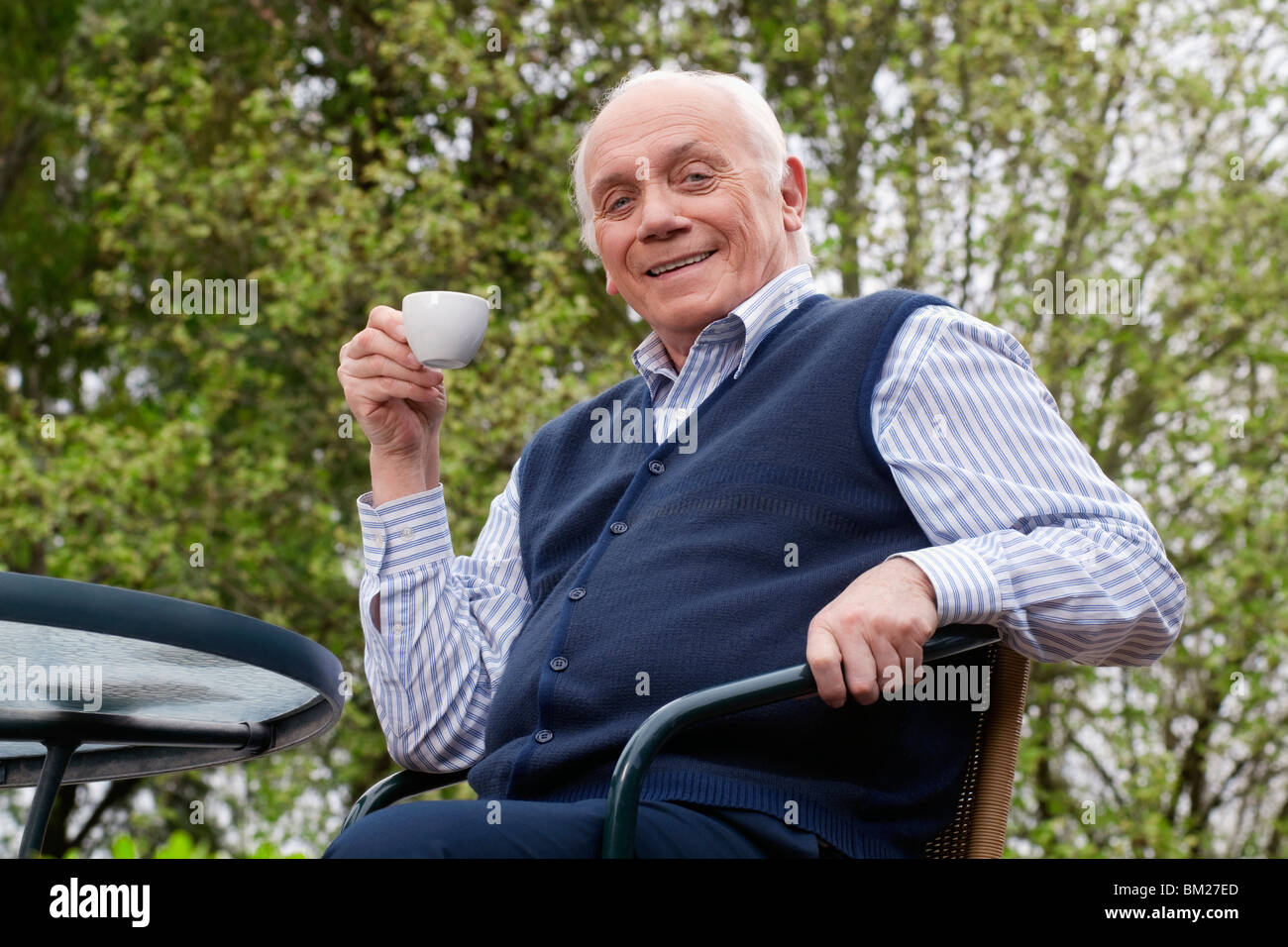 Portrait of a man sitting on a chair and drinking tea Stock Photo - Alamy