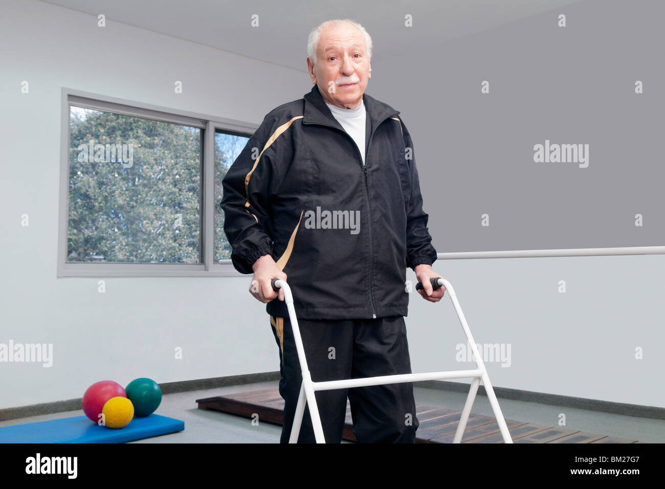 Portrait of a disabled man walking with a walker Stock Photo - Alamy
