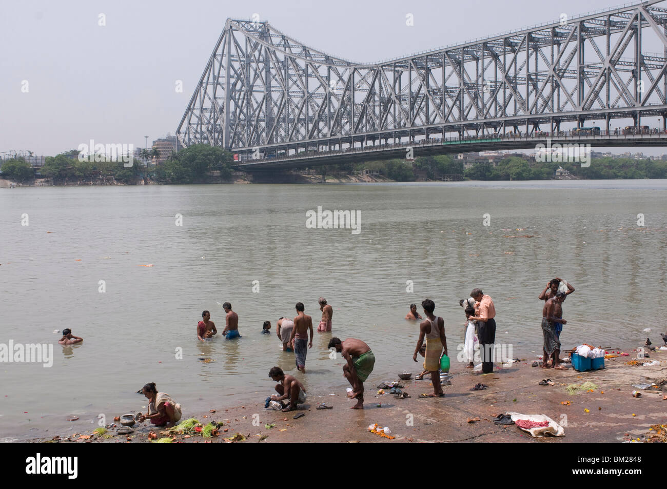 People washing in the River, Howrah Bridge in background, Kolkata, West ...