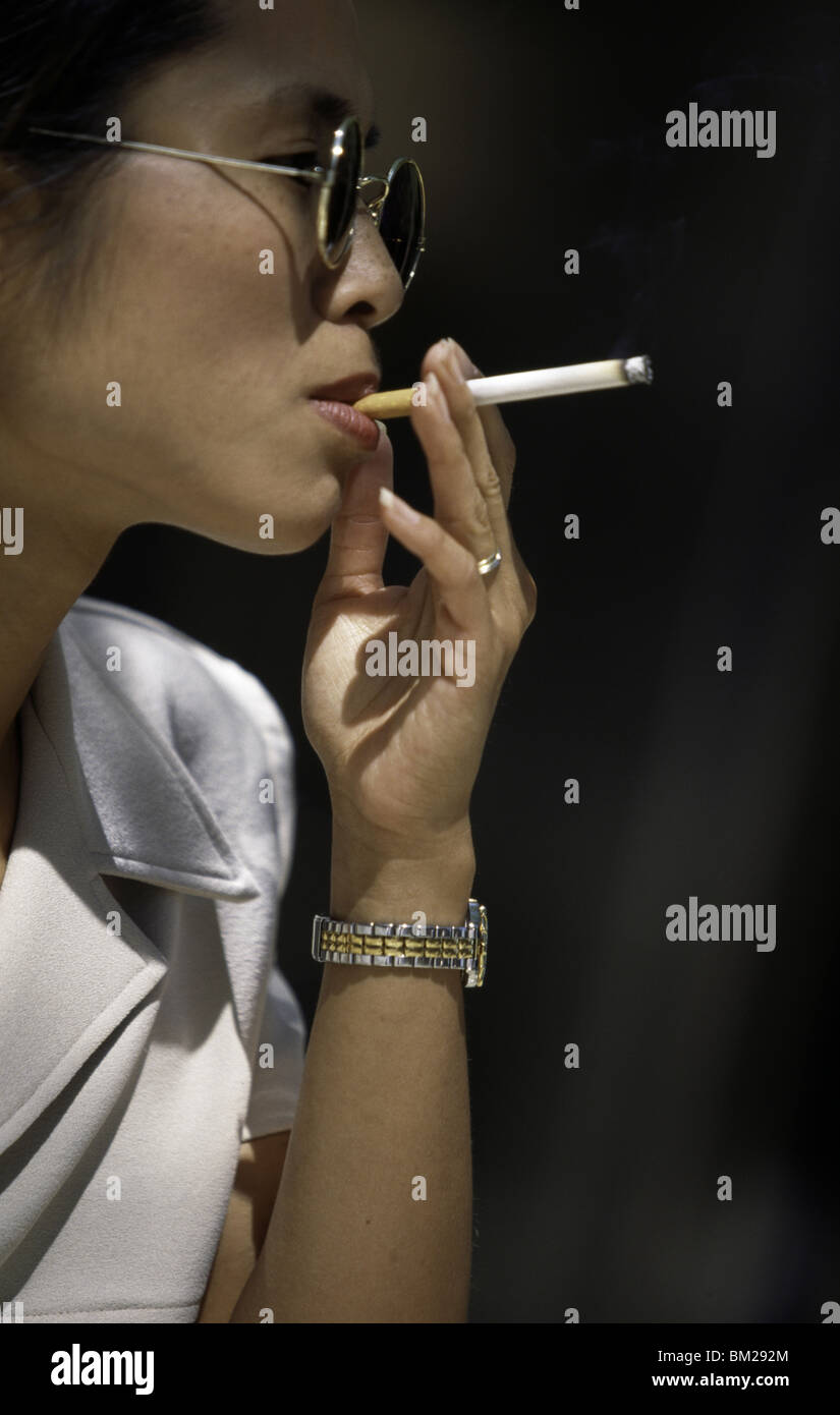 Close-up of a young woman smoking a cigarette Stock Photo - Alamy