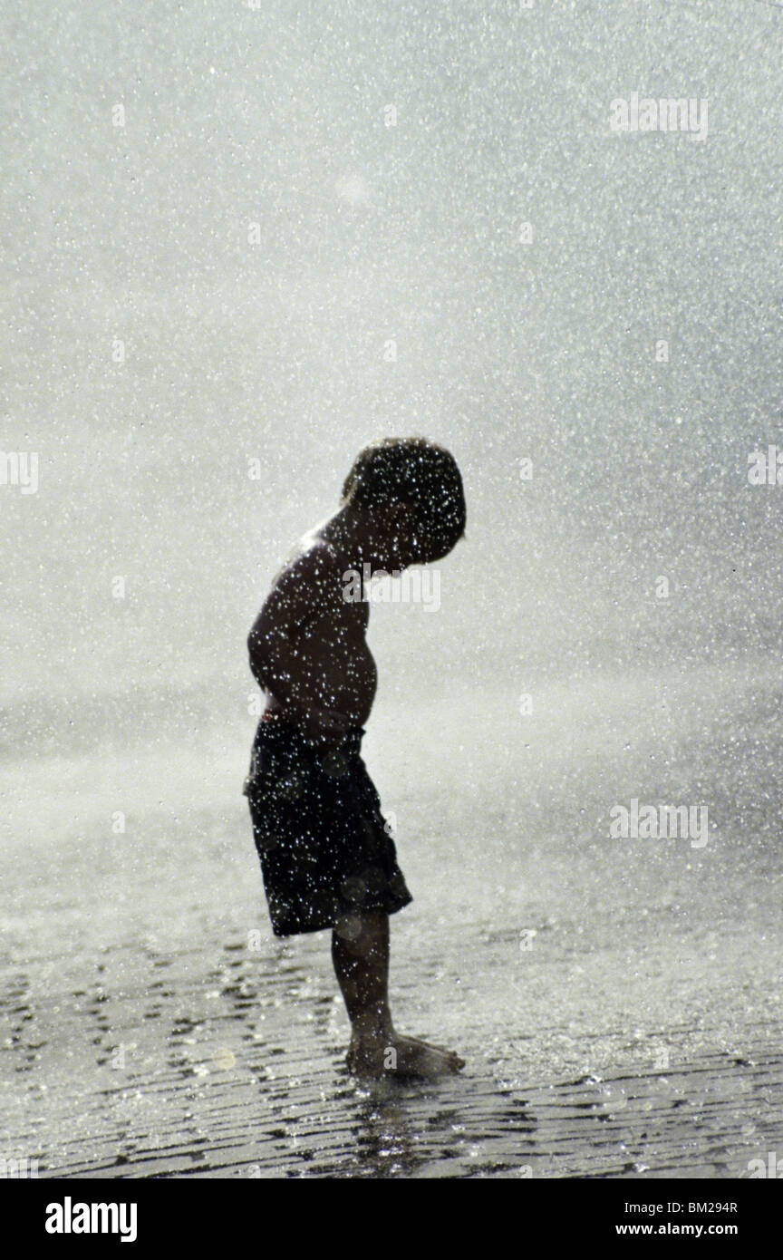 Boy enjoying in rain Stock Photo - Alamy
