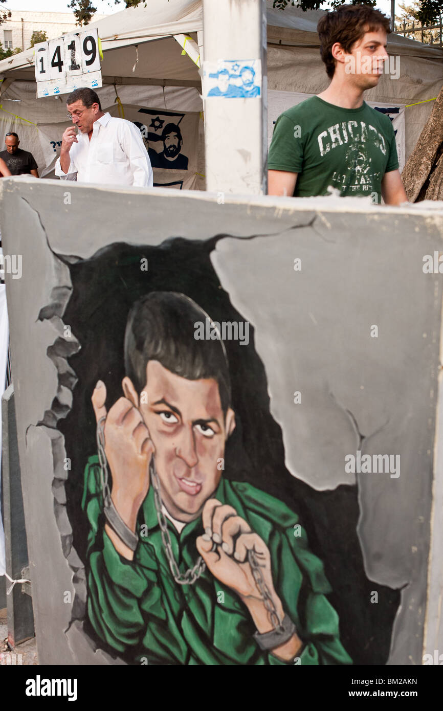 Brother Yoel Shalit walks past a painted portrait of Gilad Shalit at a ...