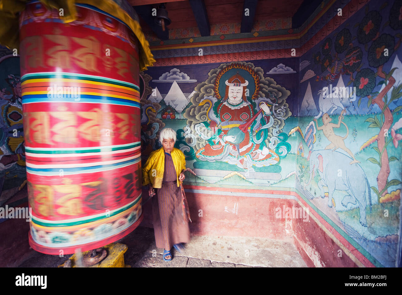 A woman spinning a prayer wheel, Chimi Lhakhang dating from 1499 ...