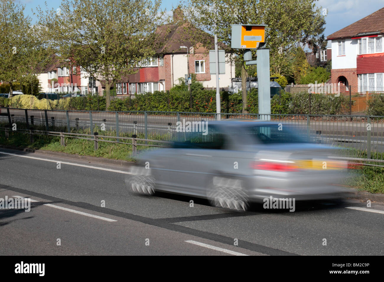 A silver car speeding past a Gatso speed camera on the A316 Great ...