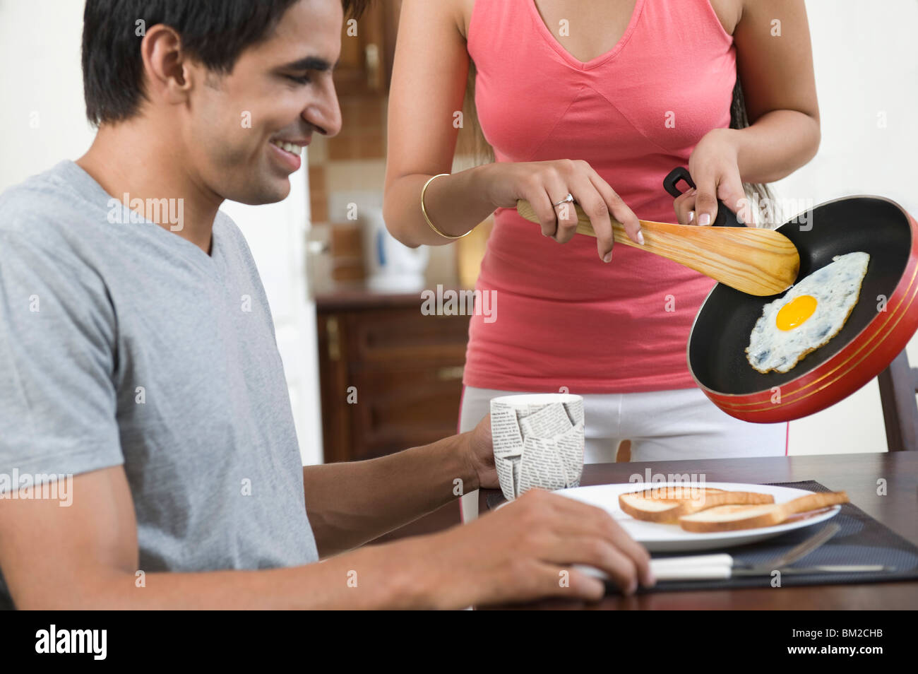 Woman serving breakfast to a man Stock Photo - Alamy