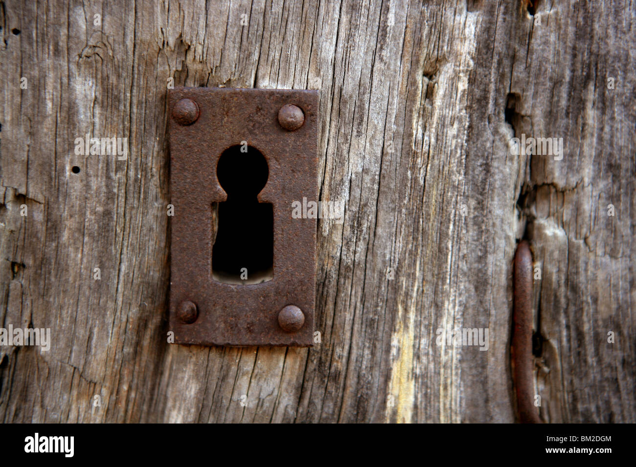 Key hole over aged gray old wood, rusty metal Stock Photo - Alamy