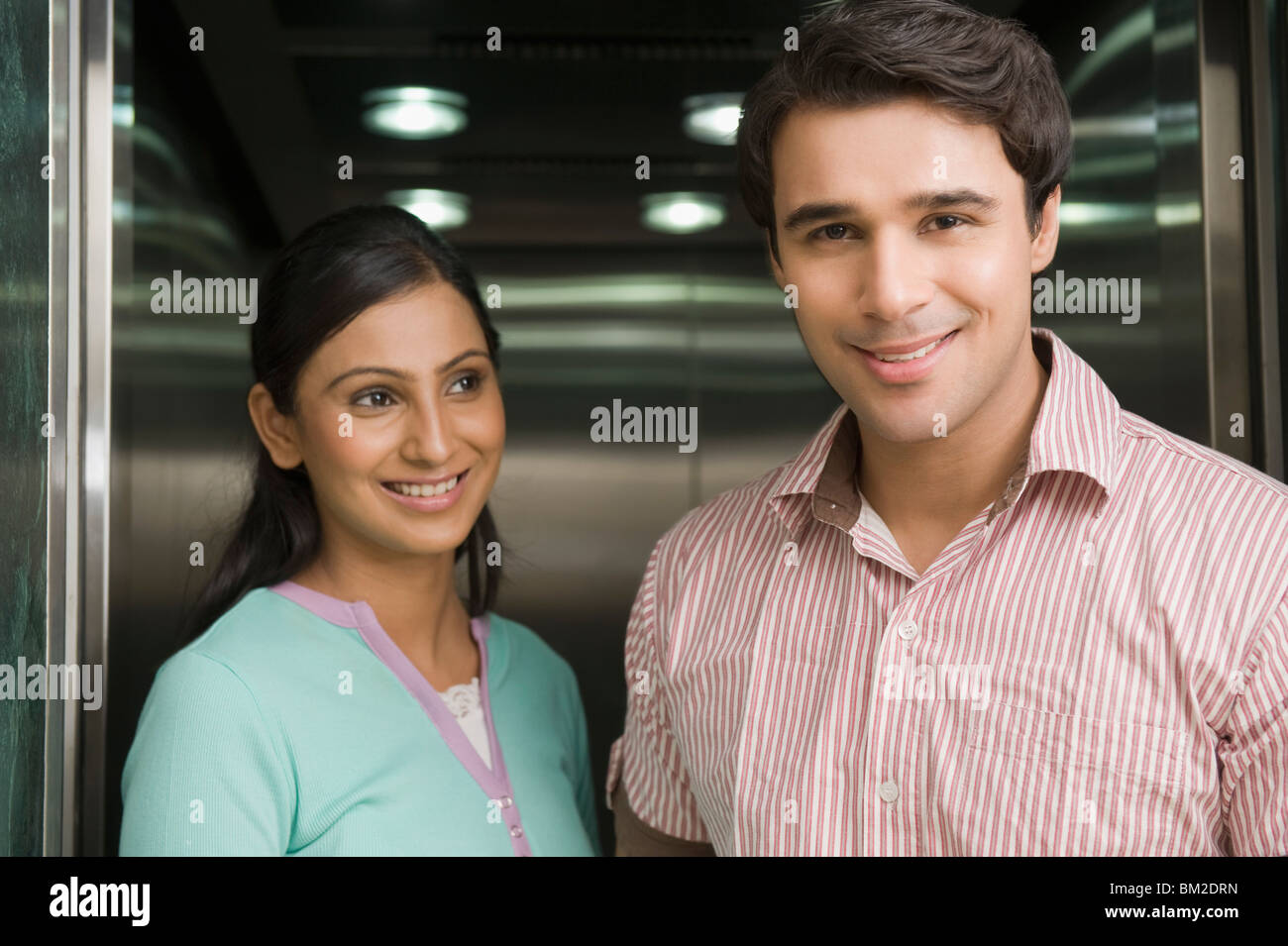 Couple smiling in an elevator Stock Photo - Alamy