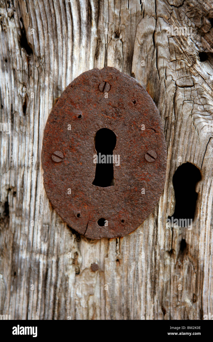 Key hole over aged gray old wood, rusty metal Stock Photo - Alamy