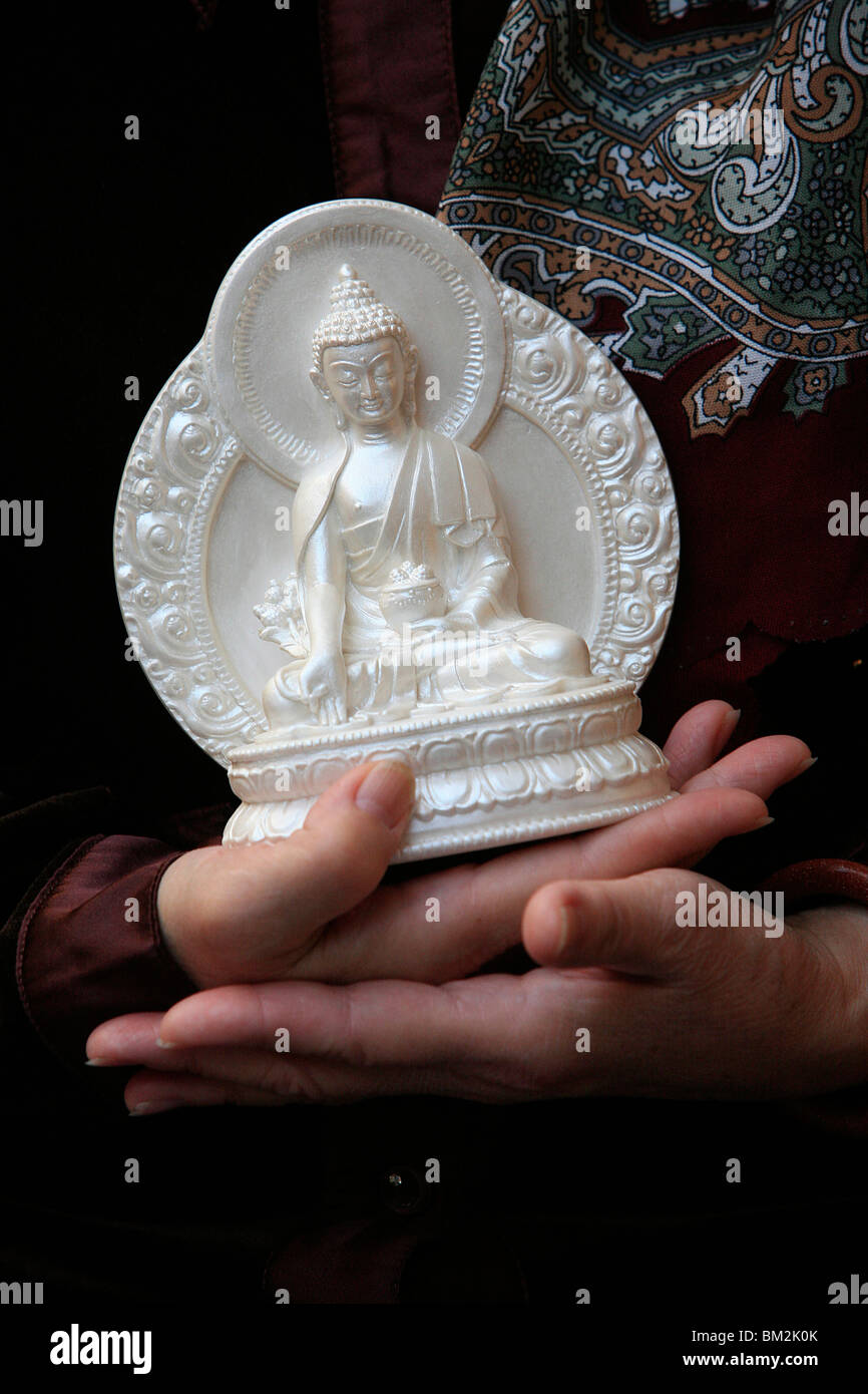 Devotee with Buddha statue, Paris, France Stock Photo - Alamy