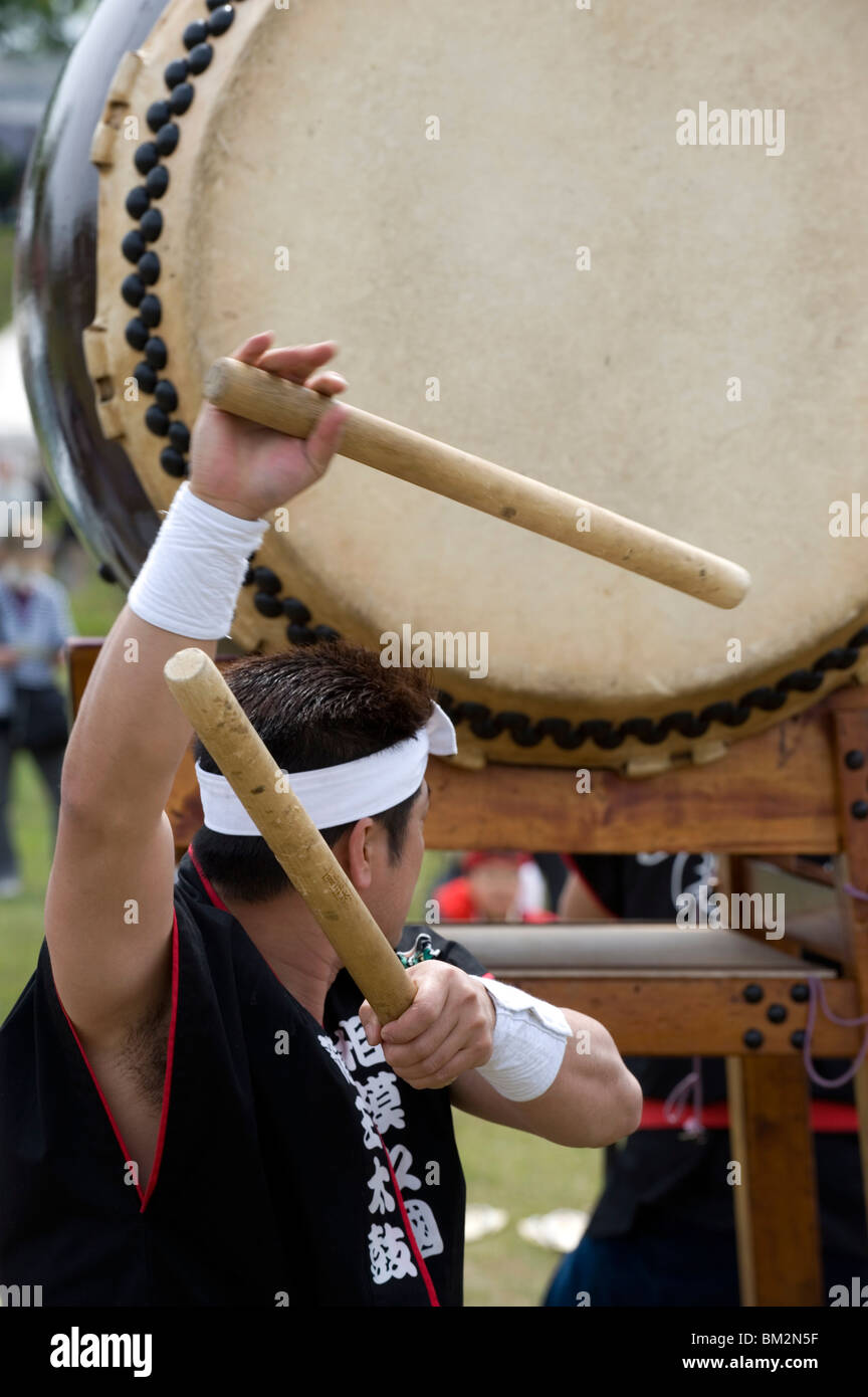 Drummer performing on a Japanese taiko drum at a festival in Kanagawa ...