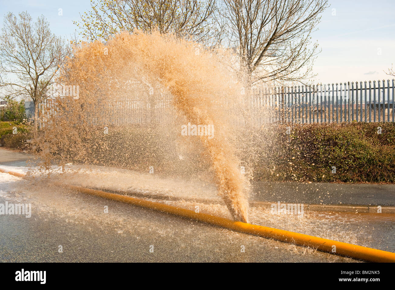 High Volume fire hose burst with water pouring out of leak Stock Photo ...