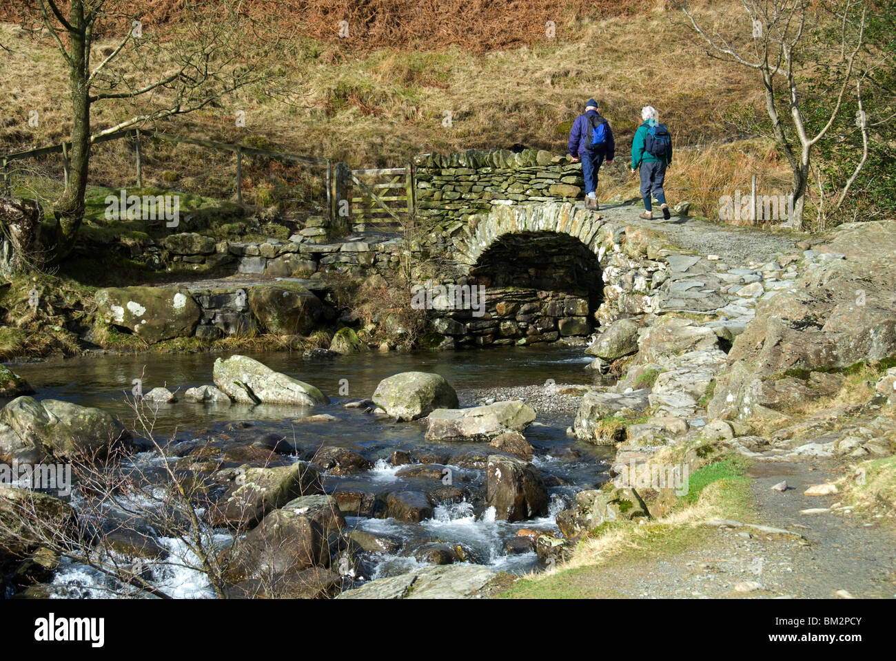 Walkers on High Sweden Bridge, a packhorse bridge over Scandale Beck ...