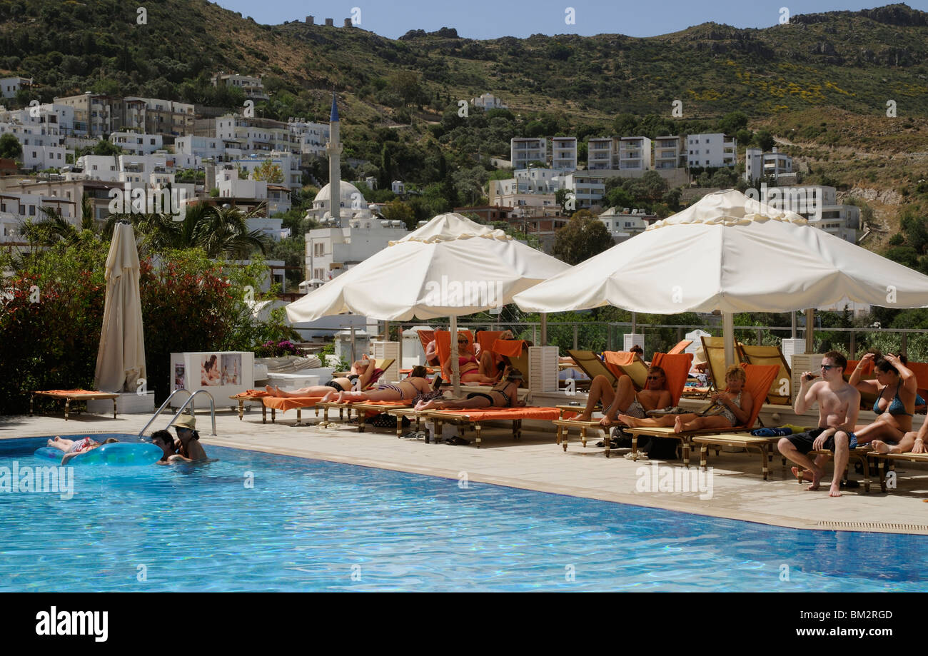 Holidaymakers sunbathing around a hotel swimming pool at Turgutreis ...