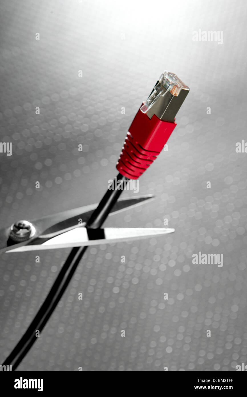 Cutting with scissors a network RJ45 red cable connection, silver ...