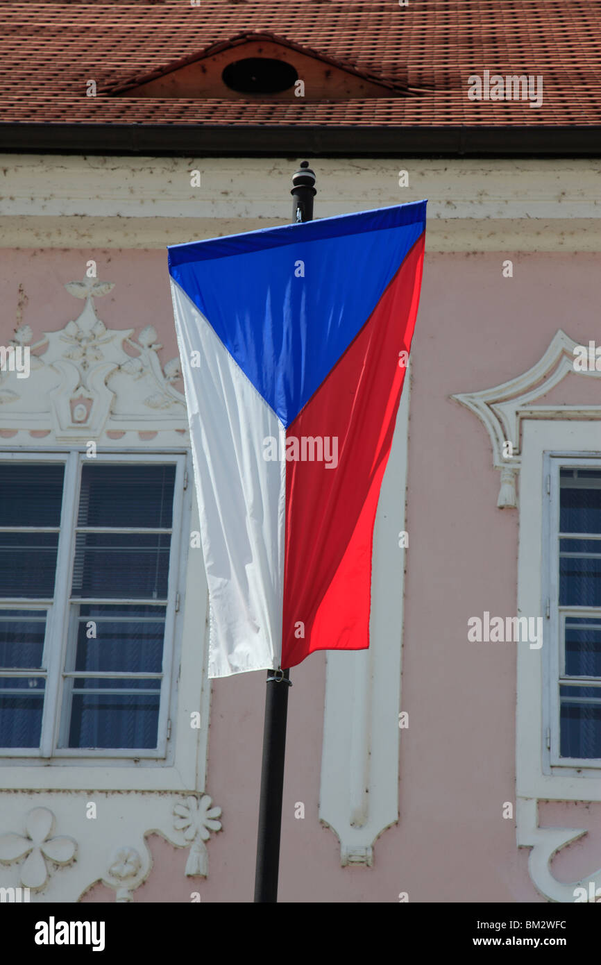 czech national flag flying in front of the facade of a historic ...