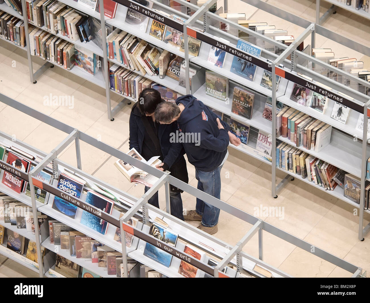 A view from above of a couple reading a book in Newcastle City Library ...