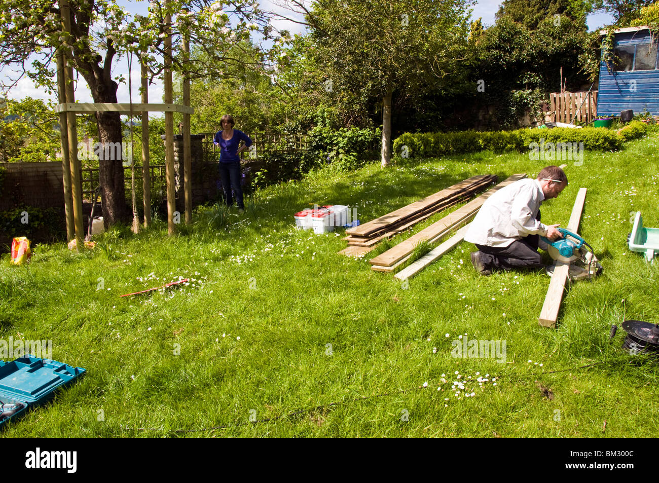 Man and woman building a treehouse around an apple tree Stock Photo - Alamy