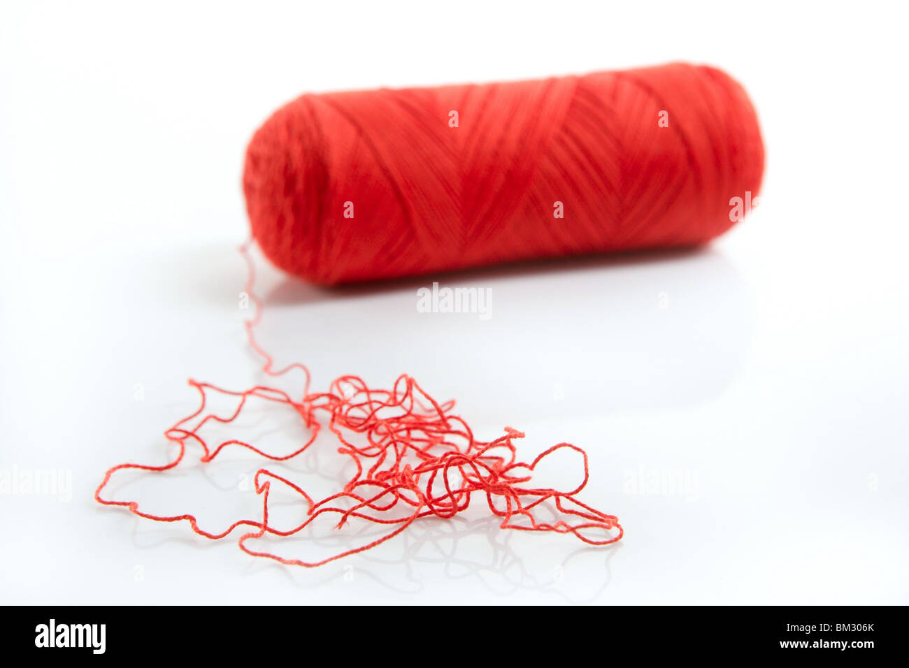 Red thread spool isolated over white studio background Stock Photo - Alamy