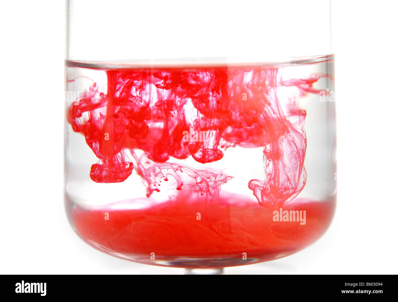 Color pigments into the water making clouds, over white background ...