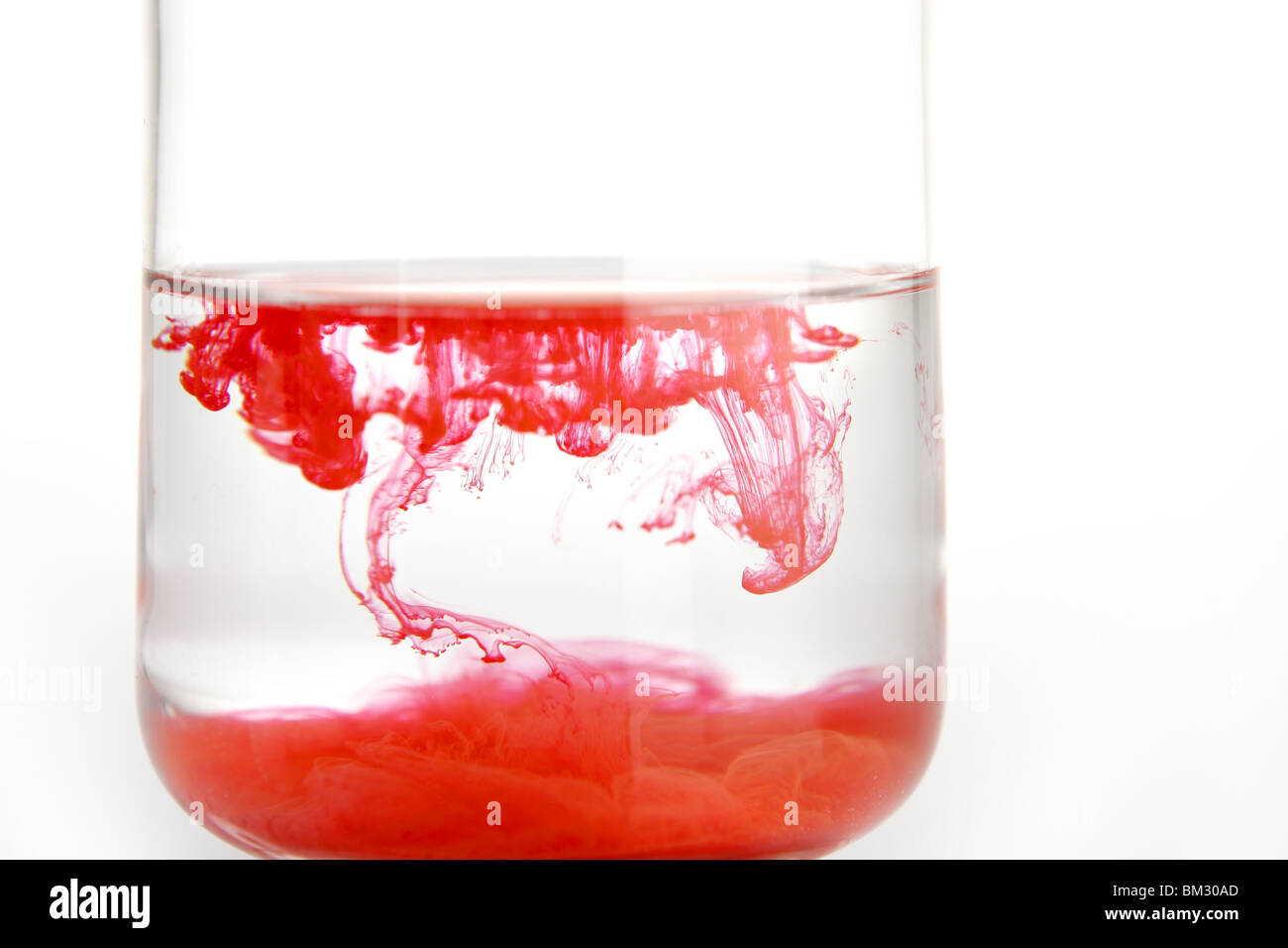Color pigments into the water making clouds, over white background ...