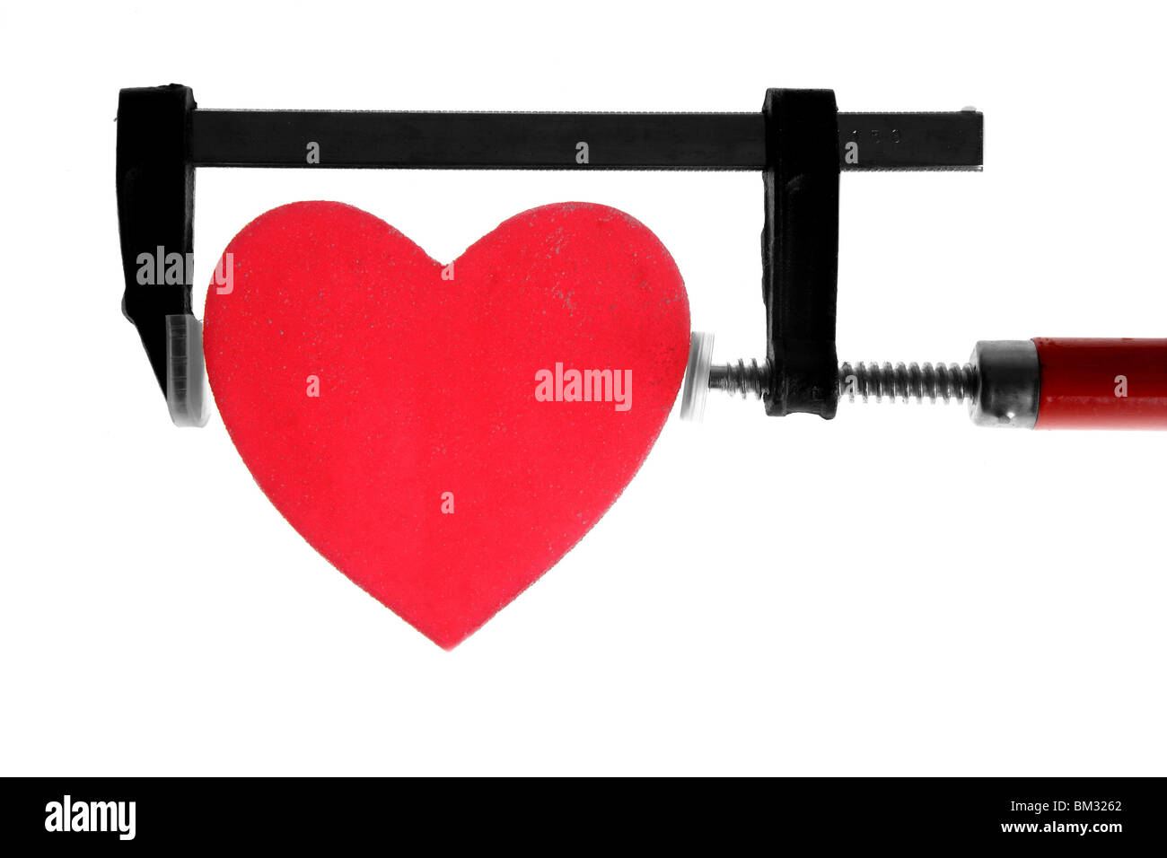 clamp grip tool pressing red heart, stress and health metaphor Stock ...