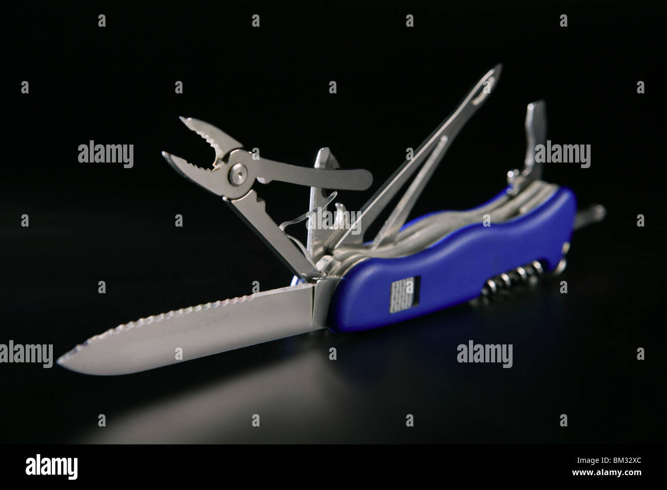Swiss multi purpose blue knife isolated on black Stock Photo - Alamy