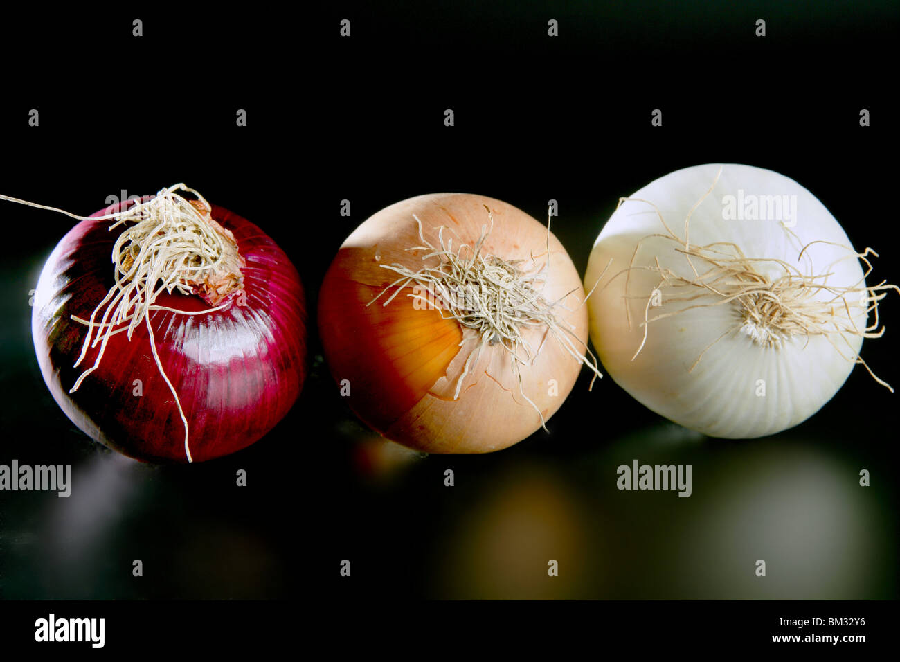 Three onion colors in a row isolated over black background Stock Photo ...