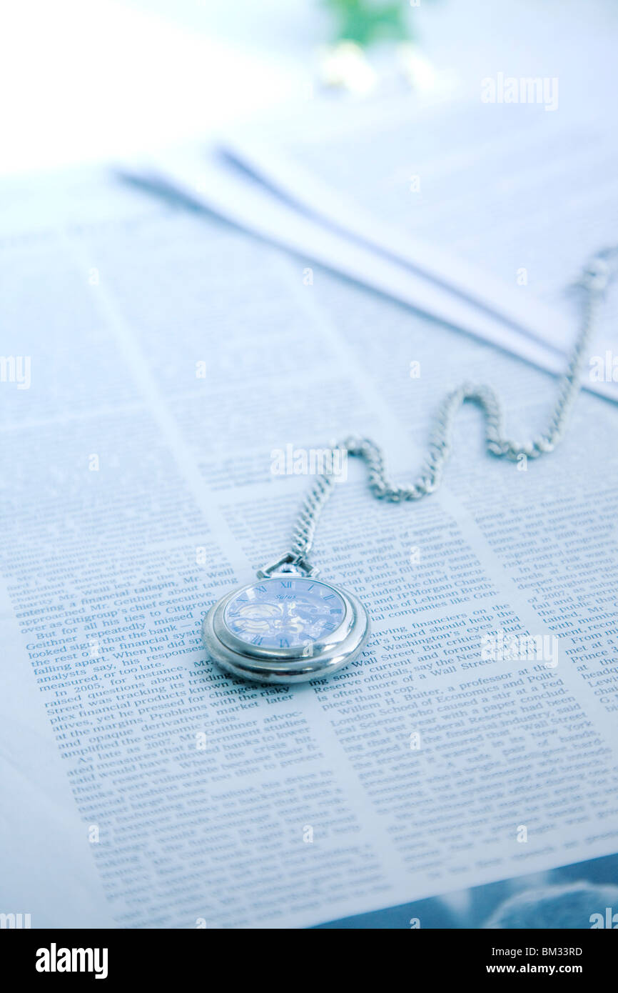 Pocket watch on newspaper Stock Photo - Alamy