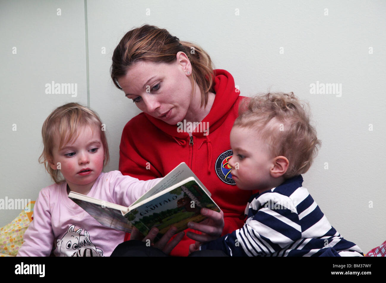 MUM READS BOOK TO TWO TODDLERS: Mum mother reads reading to her ...