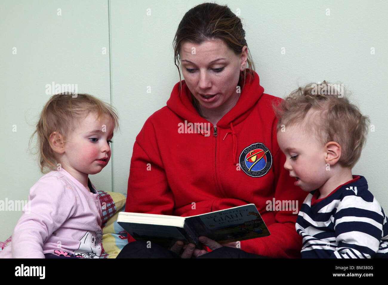 MUM READS BOOK TO TWO TODDLERS: Mum mother reads reading to her ...