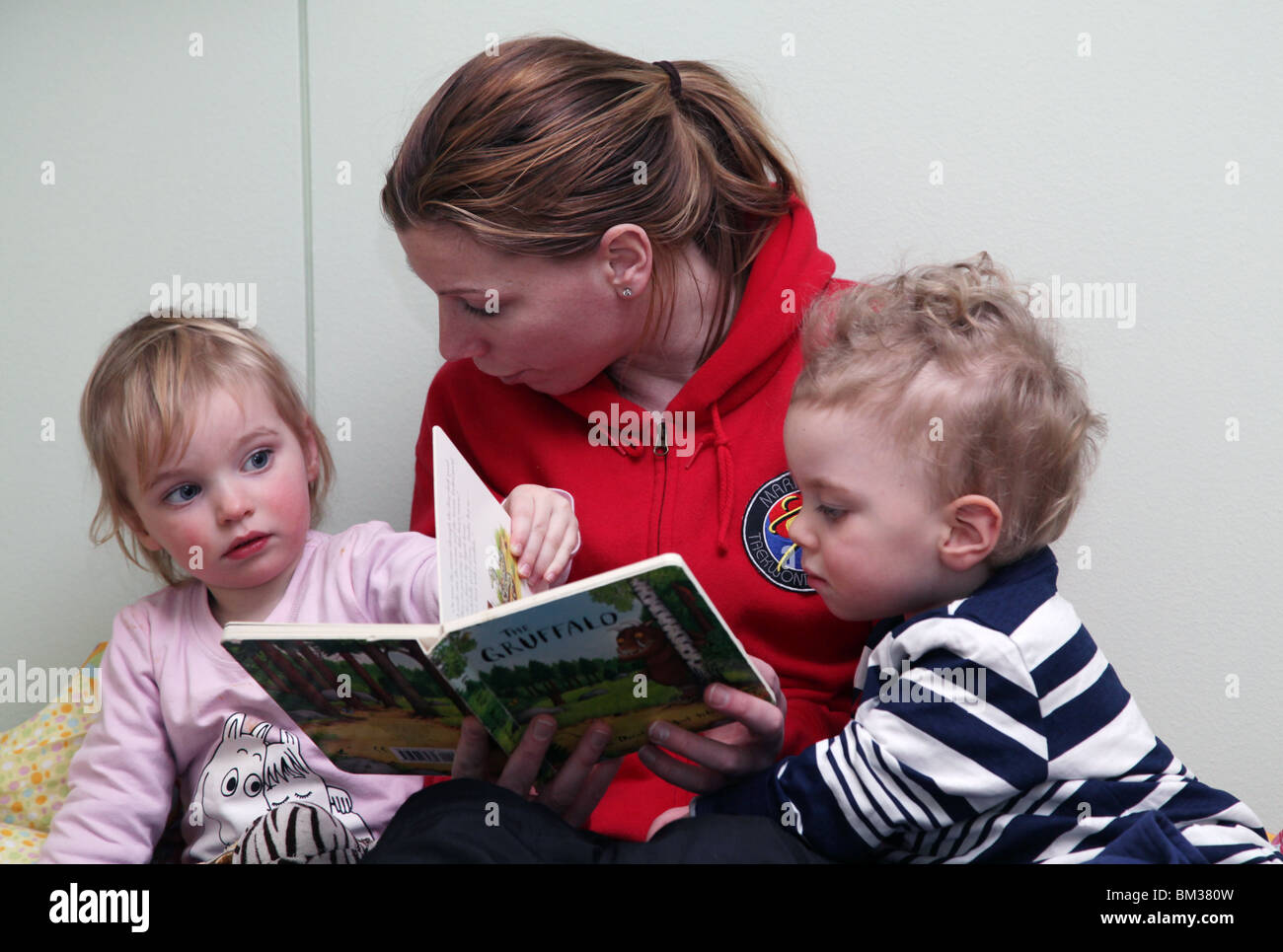 MUM READS BOOK TO TWO TODDLERS: Mum mother reads reading to her ...