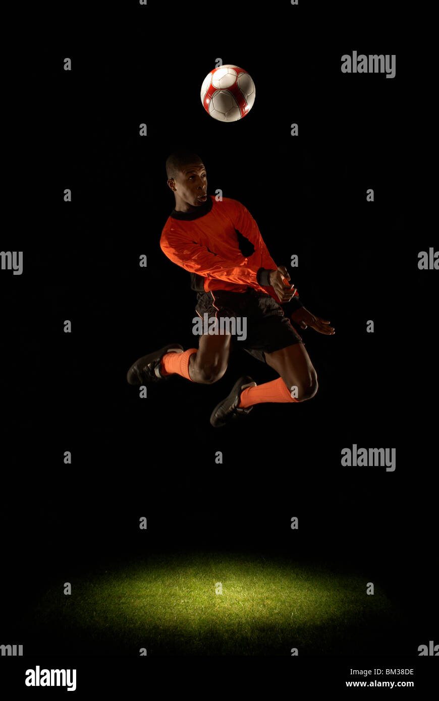 Footballer jumping for header Stock Photo - Alamy