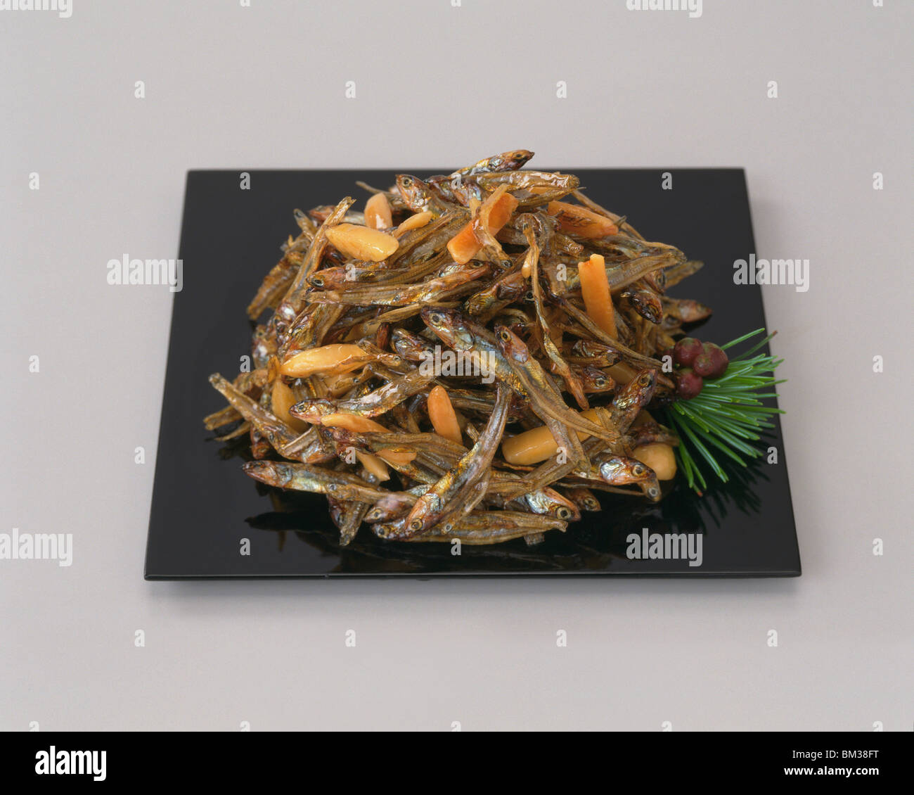 Plate of dried fish cooked with almond, white background Stock Photo ...