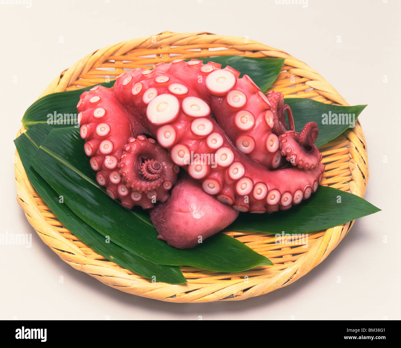 Boiled octopus on colander, white background Stock Photo - Alamy