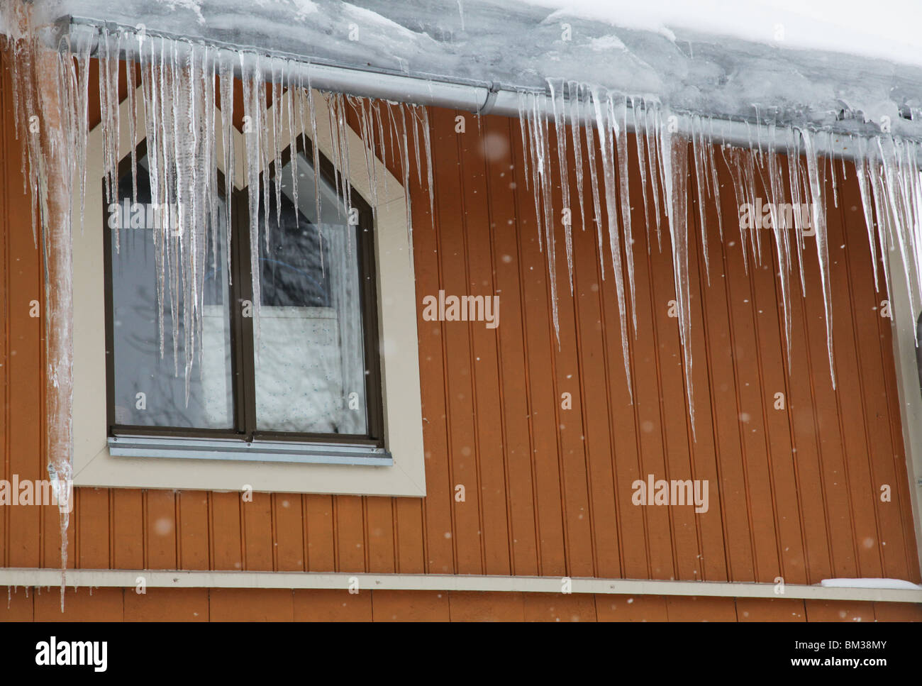 LARGE ICICLES ON NORDIC HOUSE: Large icicles on a traditional wooden ...