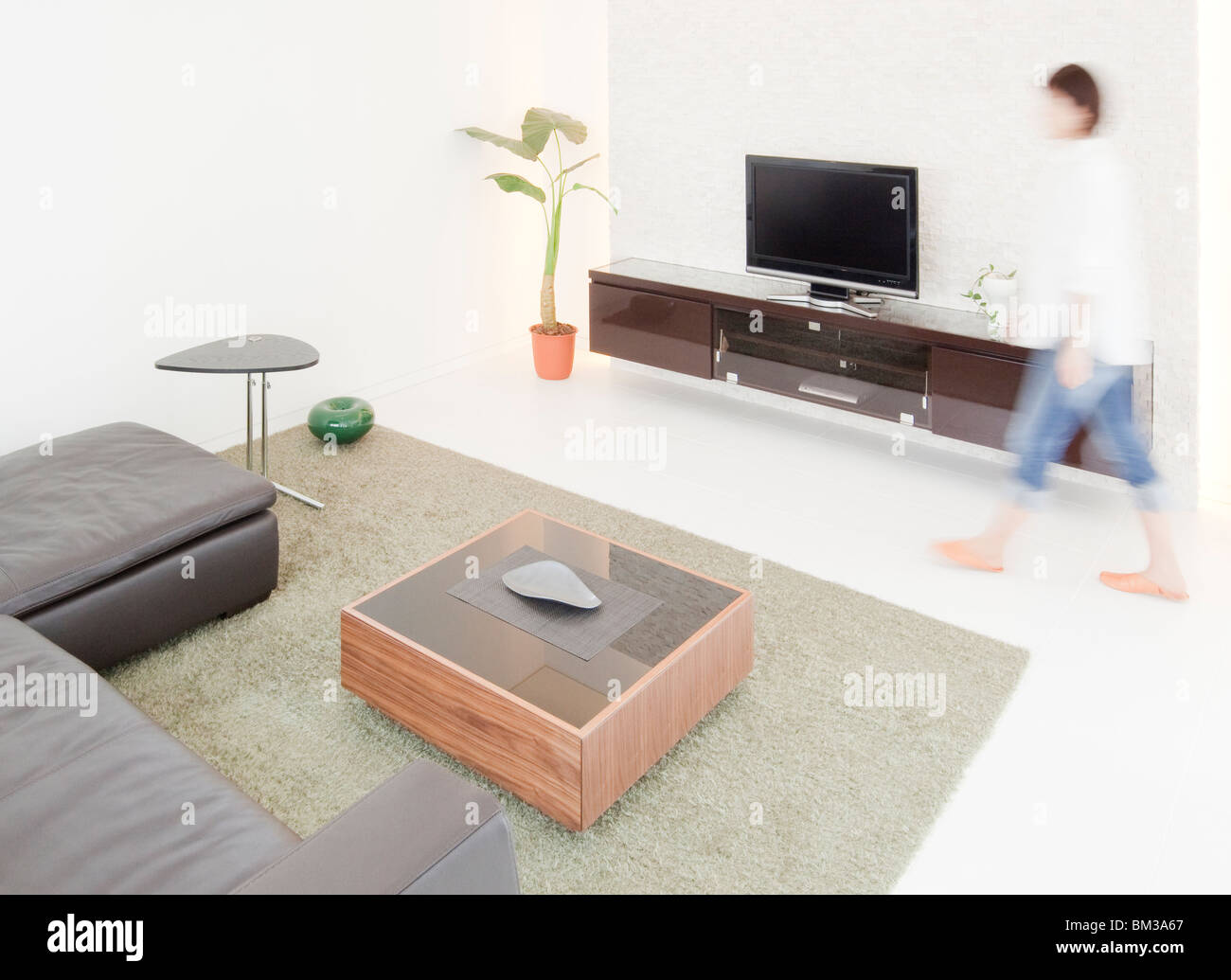 Woman walking in living room Stock Photo - Alamy