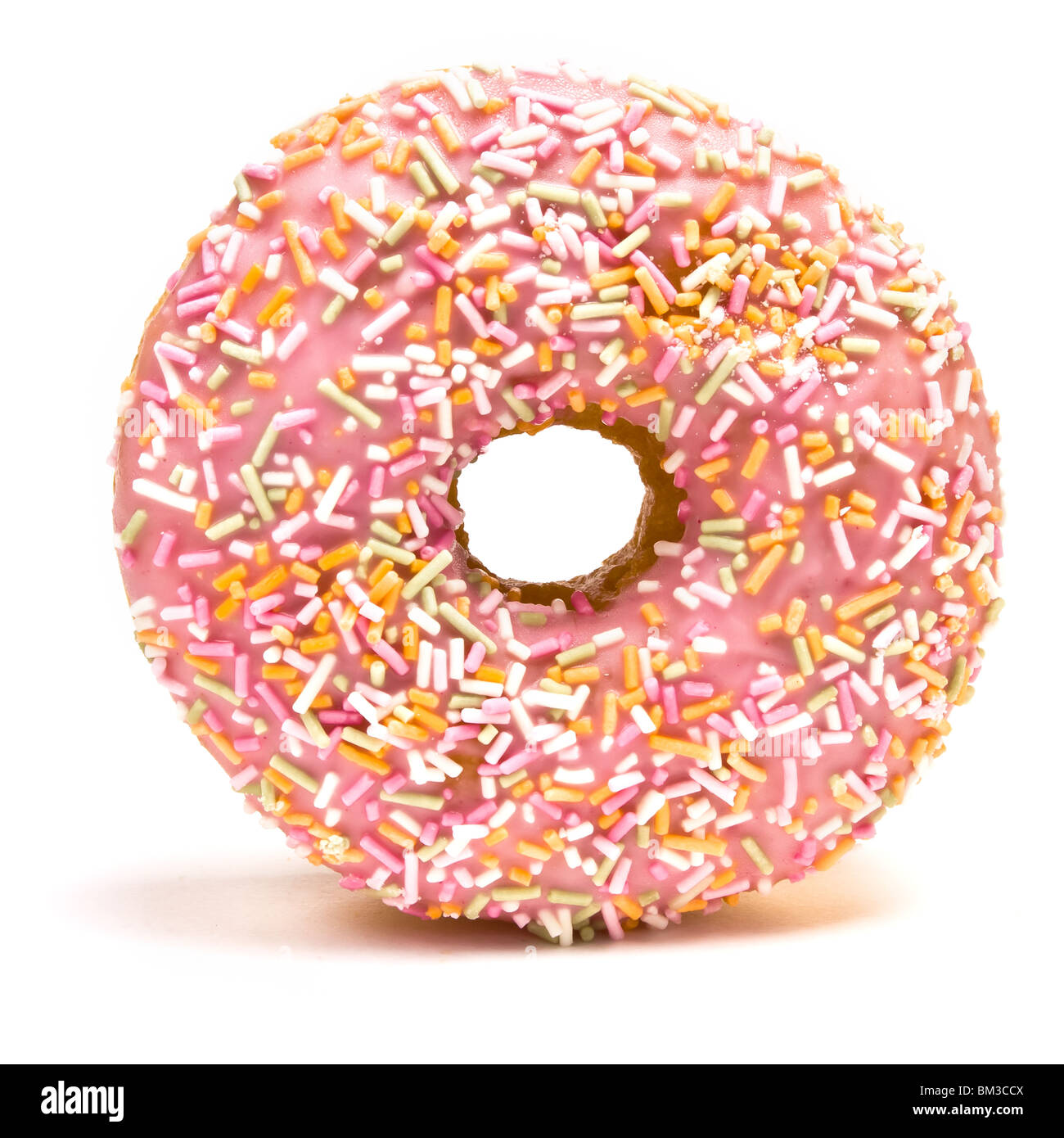 Pink Iced Doughnut covered in sprinkles isolated against white ...
