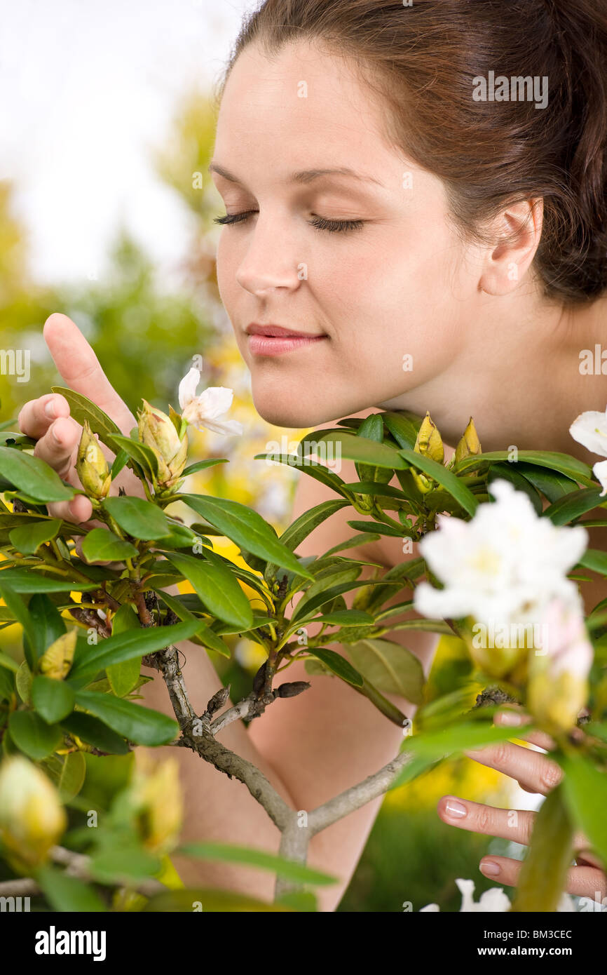 Gardening - Woman smelling blossom flower on white background Stock ...