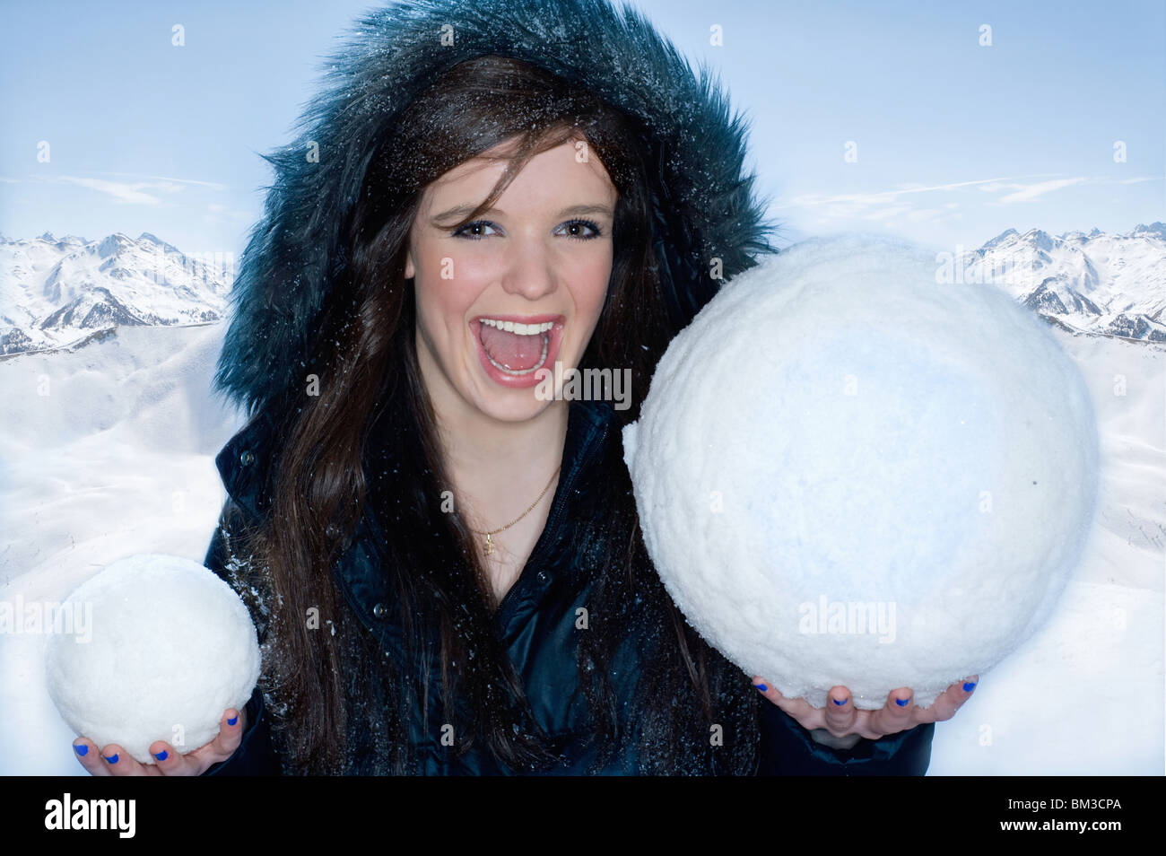 Young happy woman with two snowballs Stock Photo - Alamy