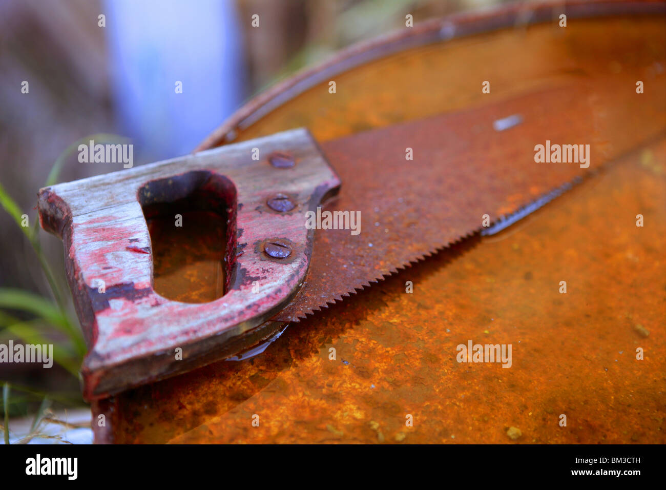Rusted old saw tool over rusty orange background Stock Photo - Alamy